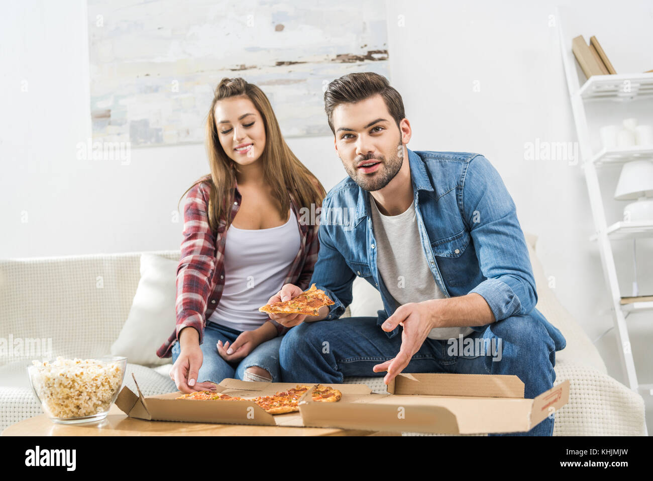 couple watching tv with snacks Stock Photo - Alamy