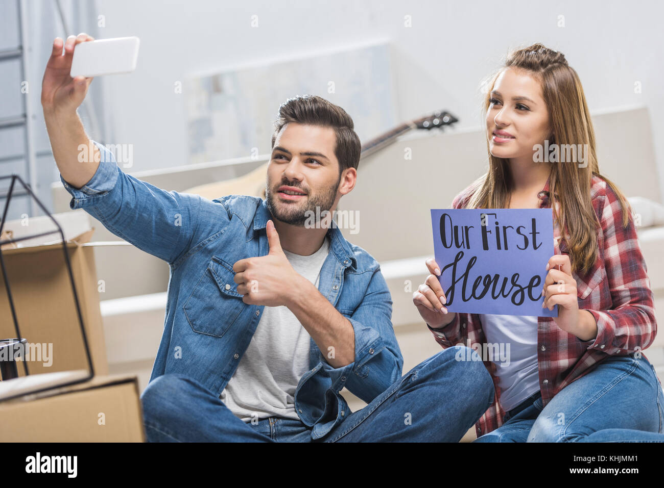 couple with our first house sign Stock Photo - Alamy
