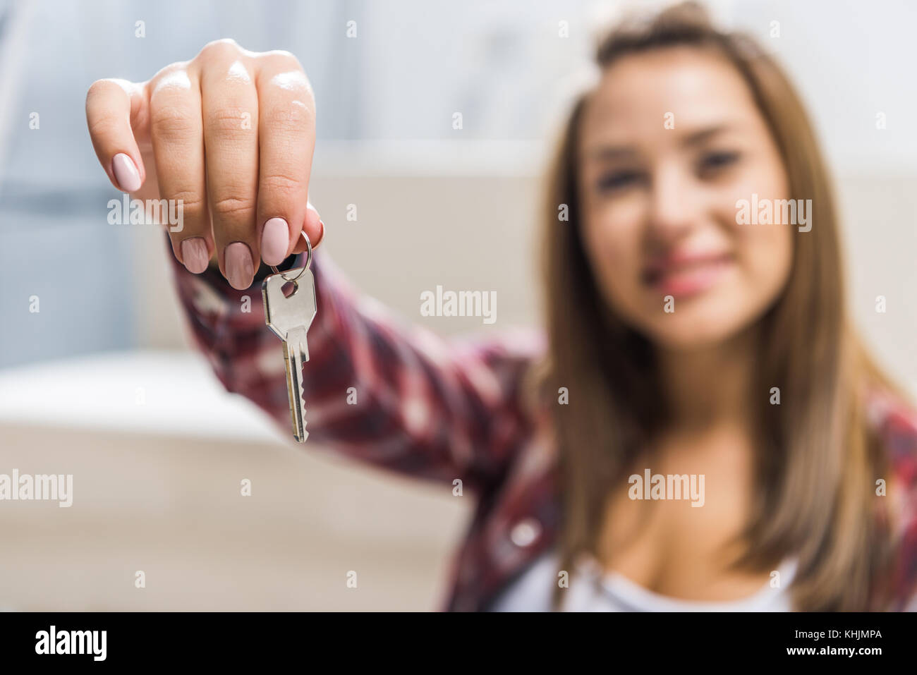 Smiling woman showing key Stock Photo - Alamy