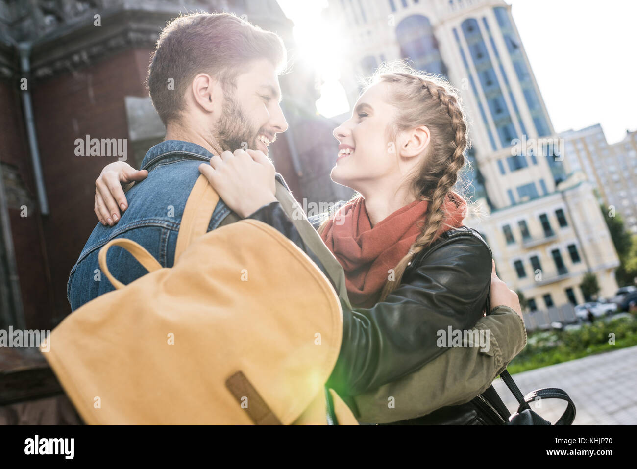 side view of smiling couple hugging each other on street Stock Photo ...