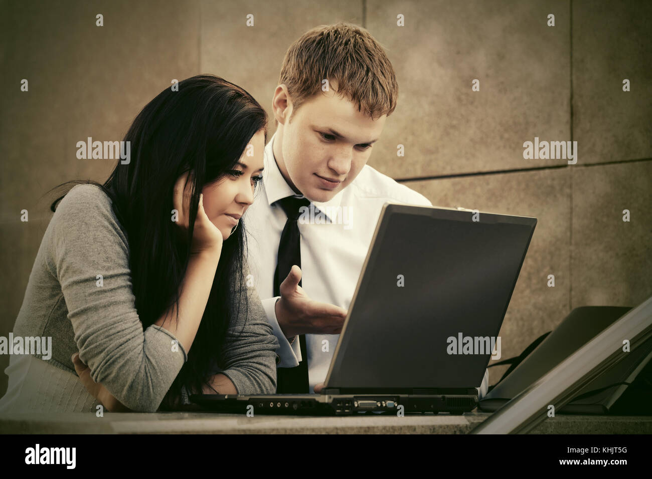 Young business couple using laptop outdoor Stock Photo - Alamy