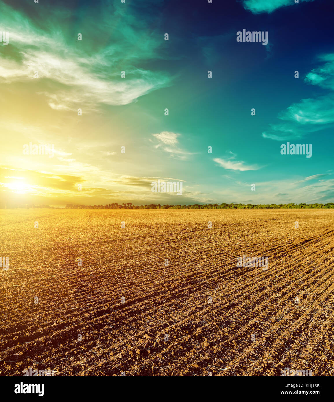 sunset in dramatic sky over plowed field Stock Photo - Alamy