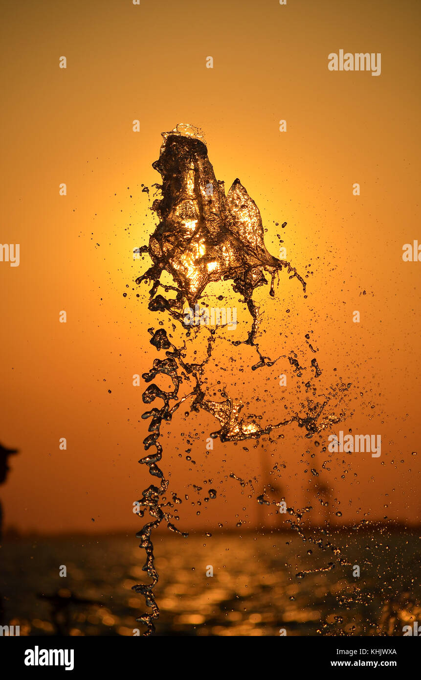 Water splash isolated on sunset colors background Stock Photo - Alamy