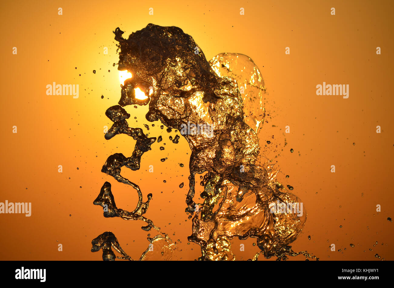 Water splash isolated on sunset colors background Stock Photo - Alamy