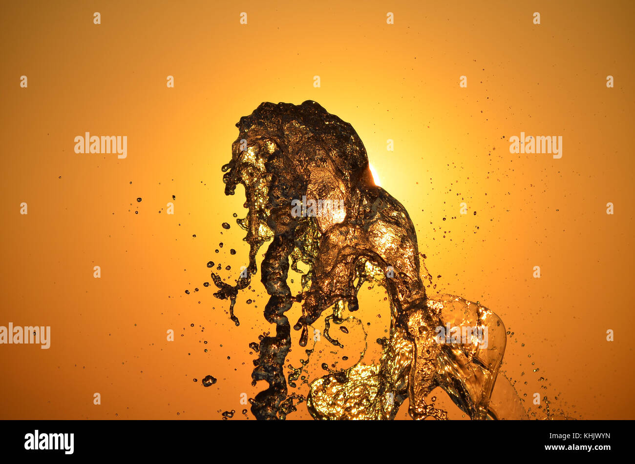 Water splash isolated on sunset colors background Stock Photo - Alamy