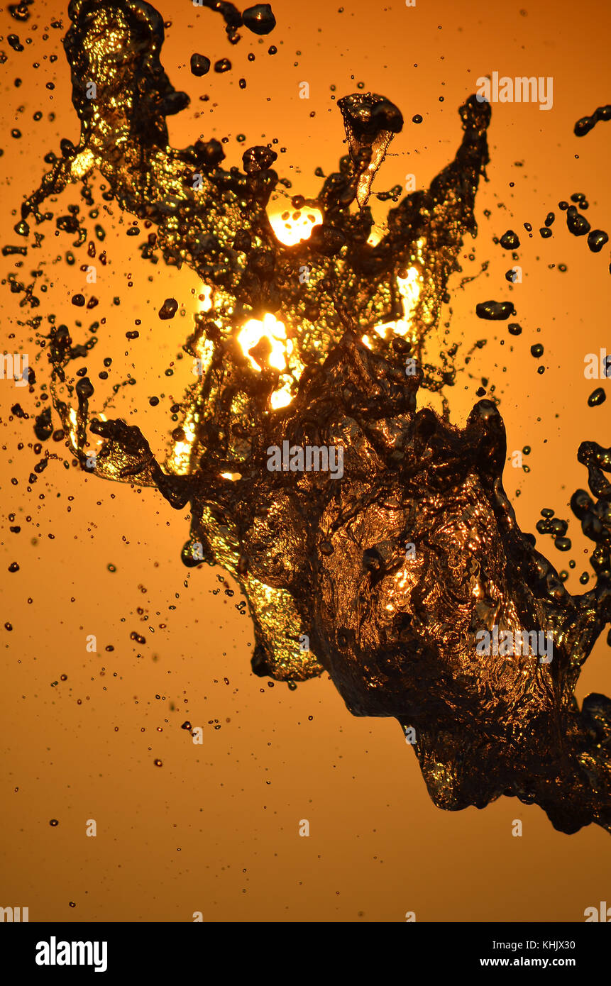 Water splash isolated on sunset colors background Stock Photo - Alamy