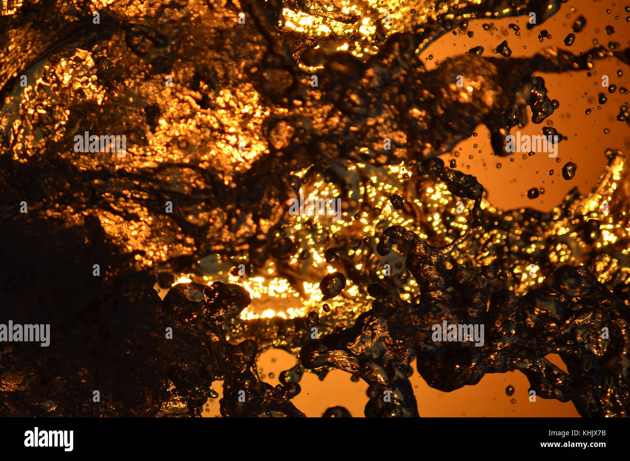 Water splash isolated on sunset colors background Stock Photo - Alamy