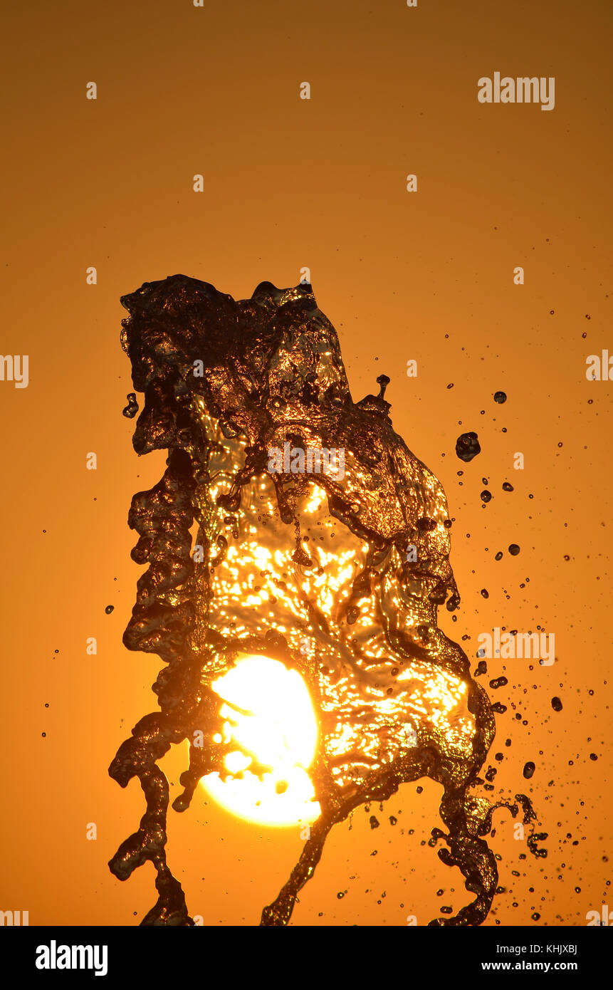 Water splash isolated on sunset colors background Stock Photo - Alamy