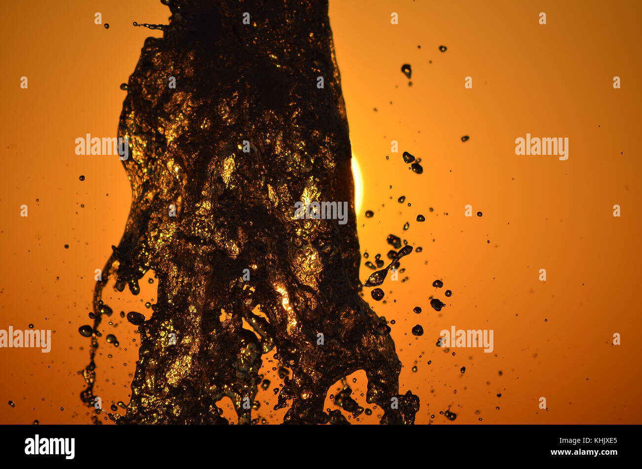 Water splash isolated on sunset colors background Stock Photo - Alamy
