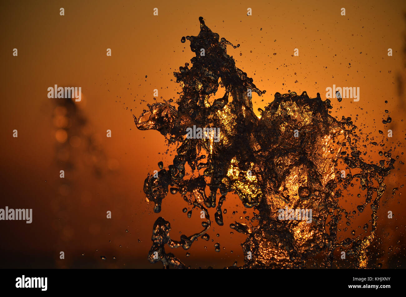 Water splash isolated on sunset colors background Stock Photo - Alamy