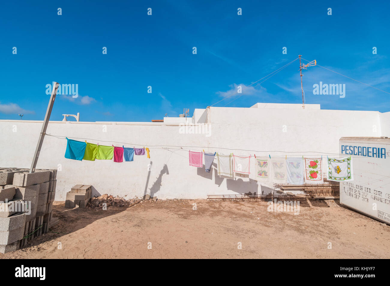 view of a typical street of Caleta del Sebo with color clthes hanging ...