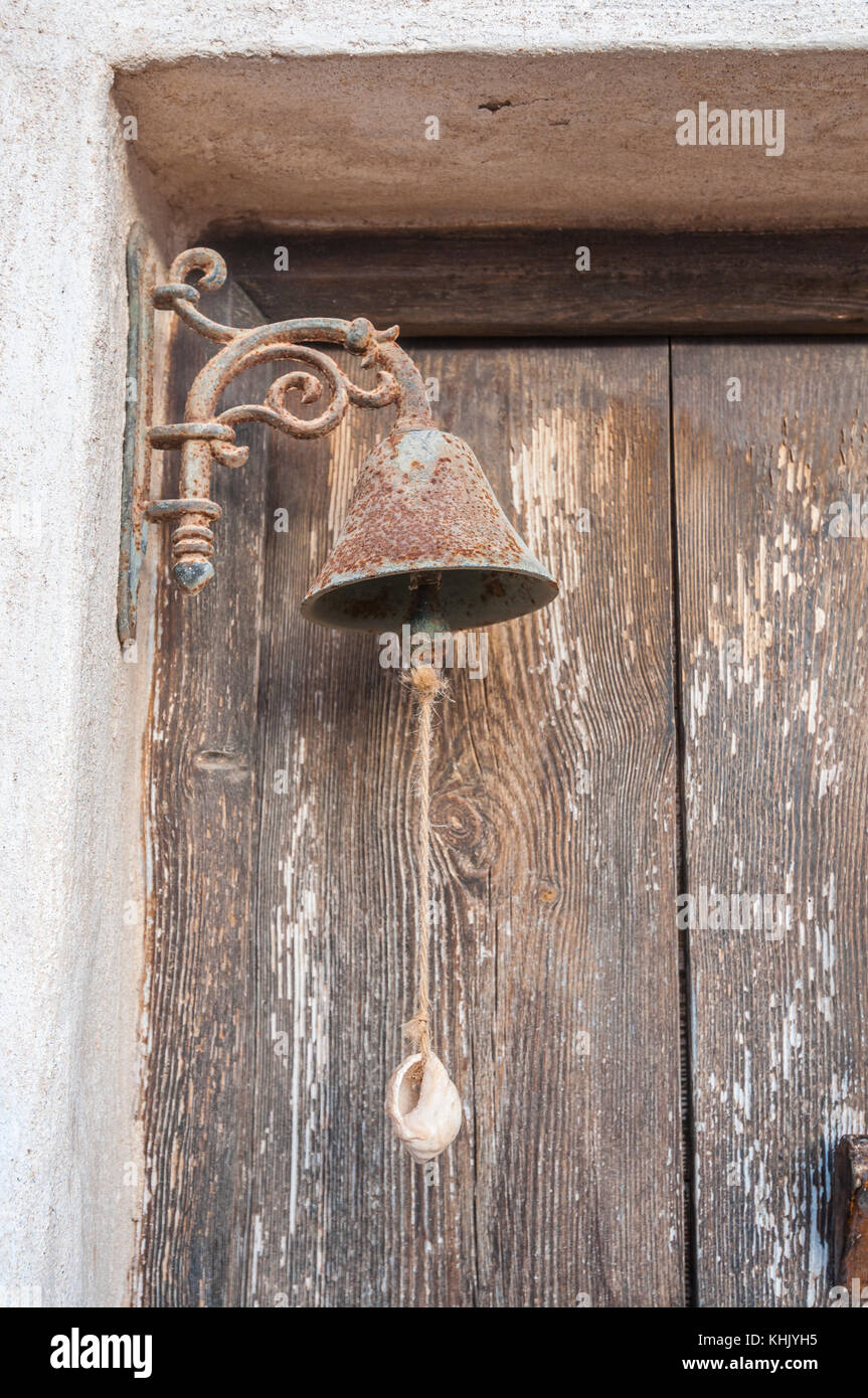 Doorbell made with an old metal bell on an old wooden door, La Graciosa ...