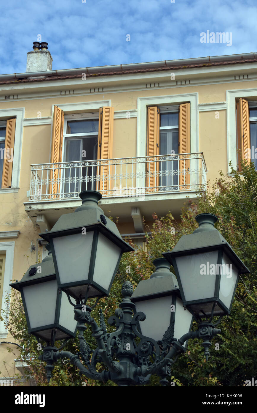 an antique or older style lamp post in front of a typically greek ...