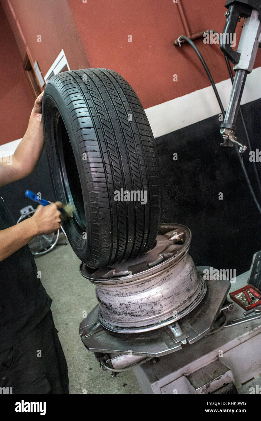 Car mechanic hands lubricating tire before mounting the rim. Installing ...