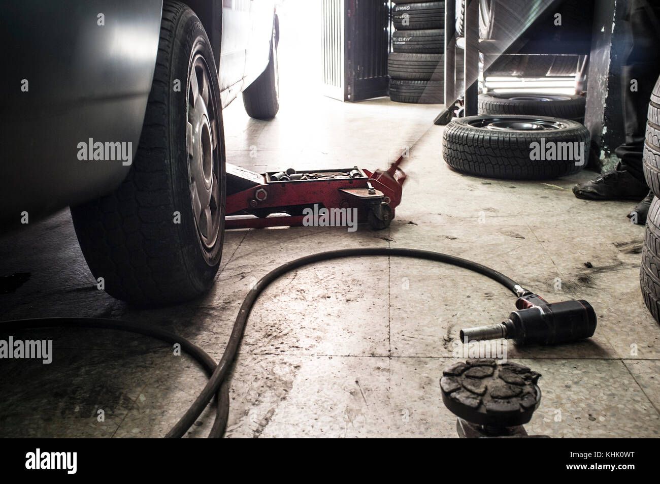 Mechanic rising a van. He is using a jack for tire change. Motion ...
