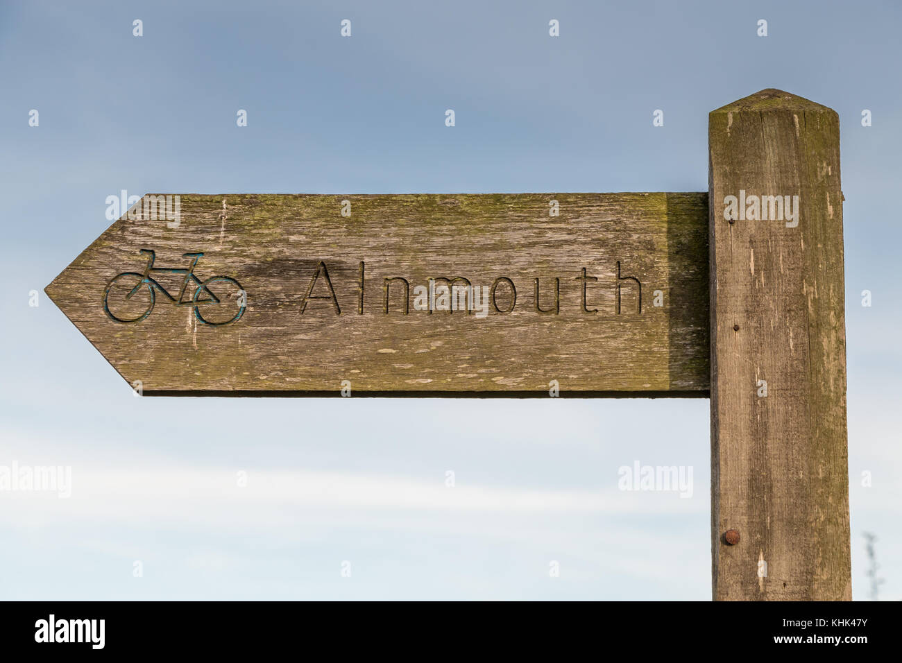 Wooden signpost with faded blue painted cycle emblem on the ...
