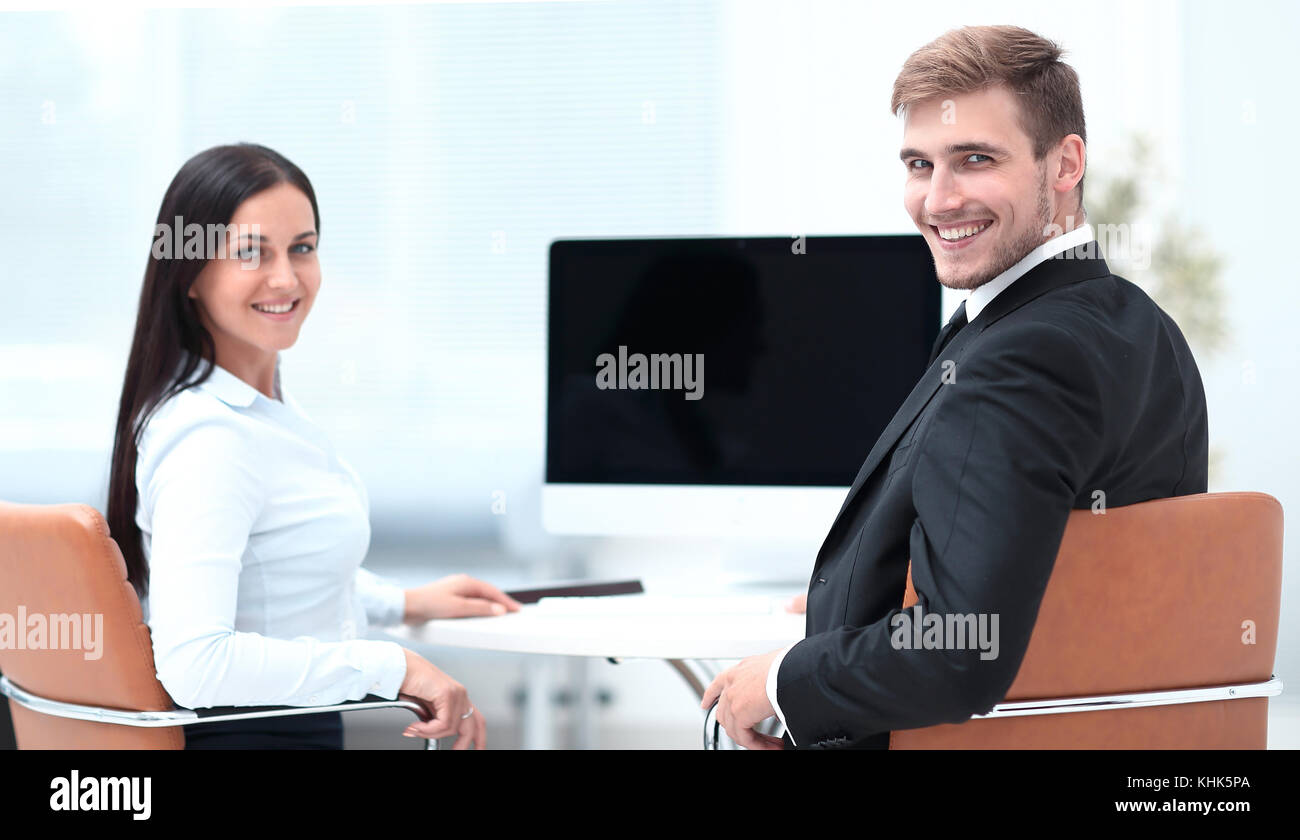 two successful employee sitting behind a Desk Stock Photo - Alamy