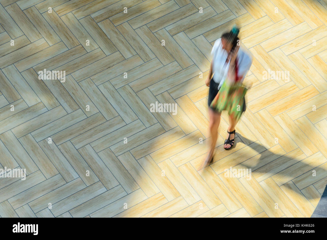 Silhouette of a walking woman with long shadow from above. Abstract ...