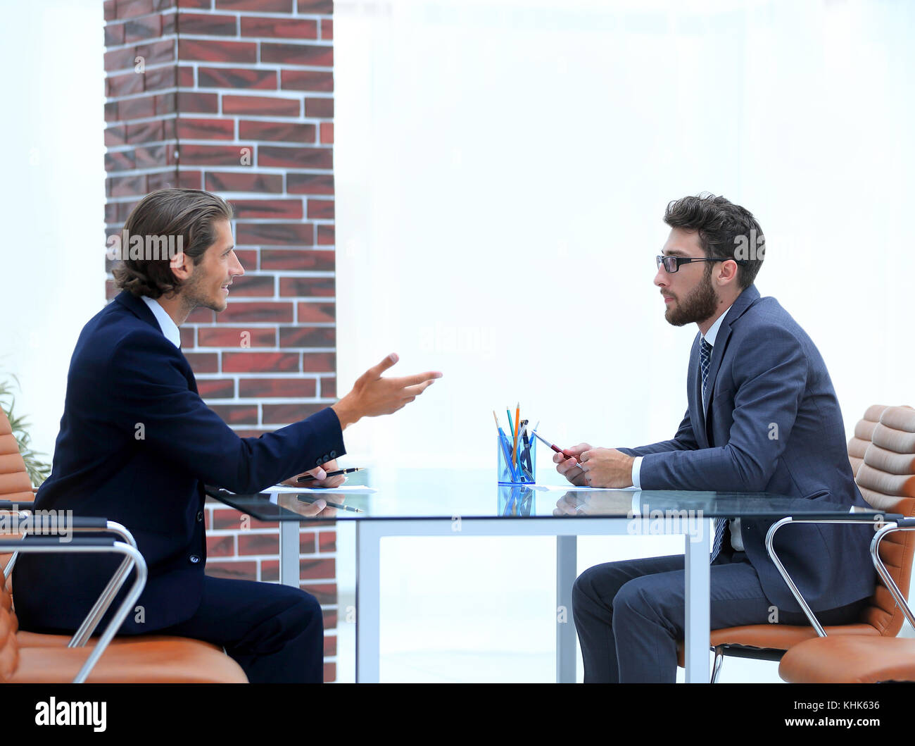 business partners talking while sitting at your Desk Stock Photo - Alamy