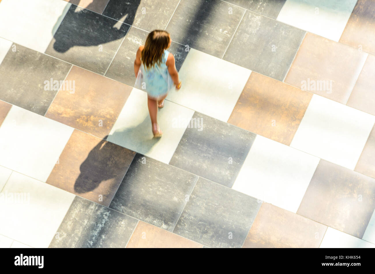 Little baby girl catching something, rear view from above. Abstract ...