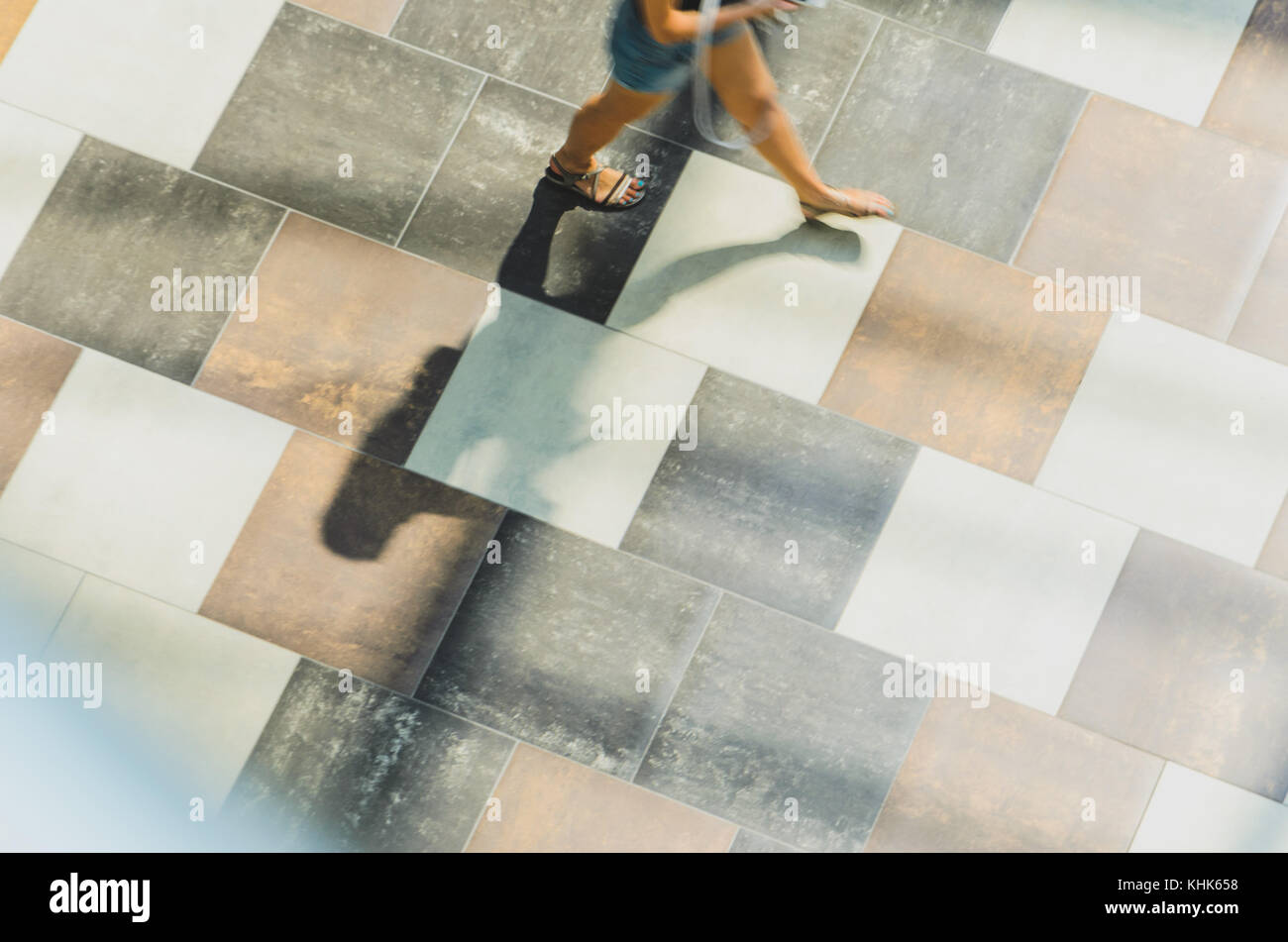 Silhouette of a walking woman with long shadow from above. Abstract ...