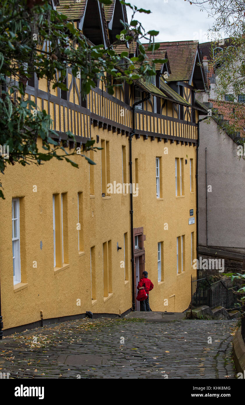 A postman knocking on a door in Dean Village, Edinburgh, Scotland Stock ...