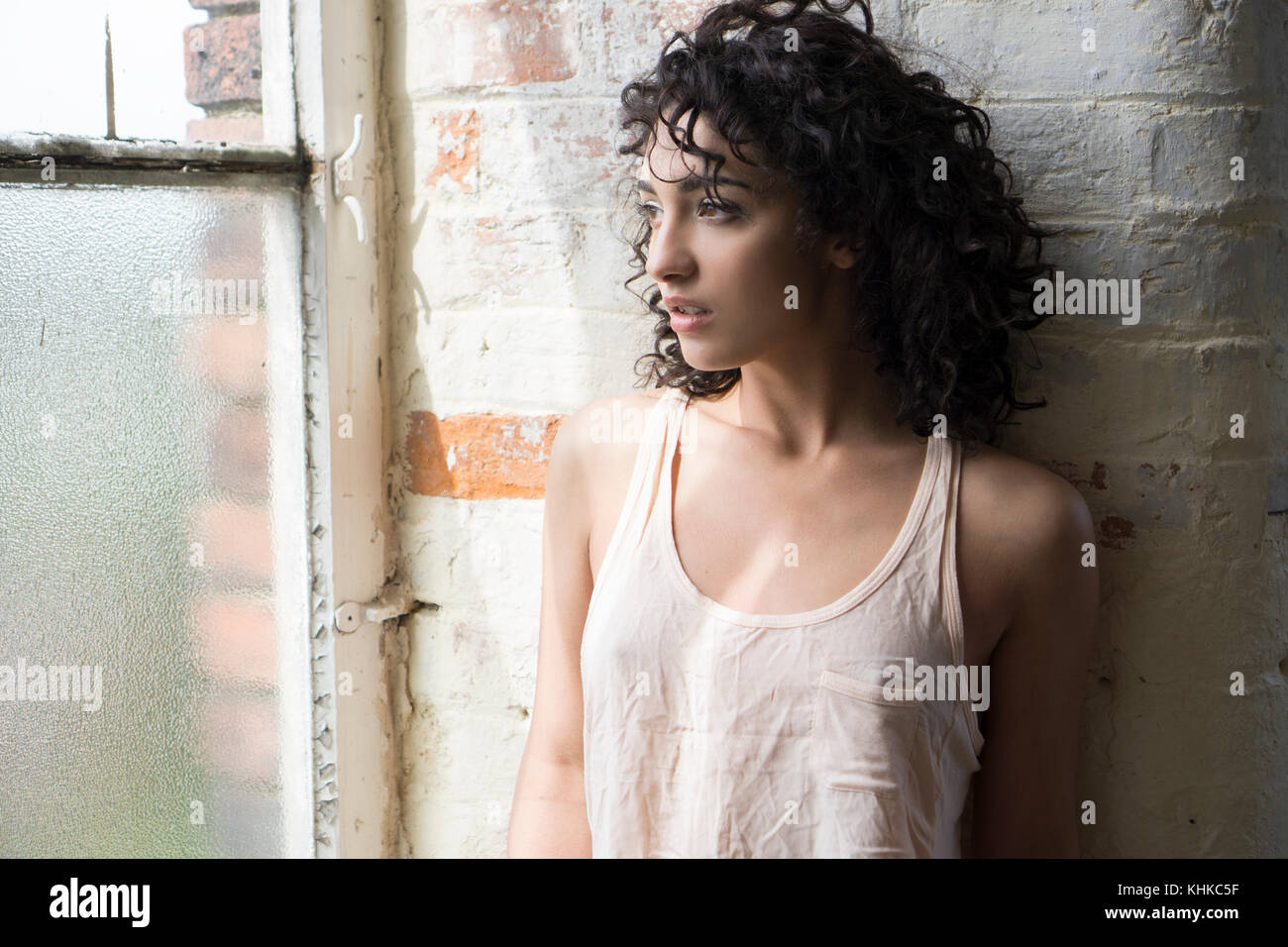 Serious young woman looking out of the window Stock Photo - Alamy