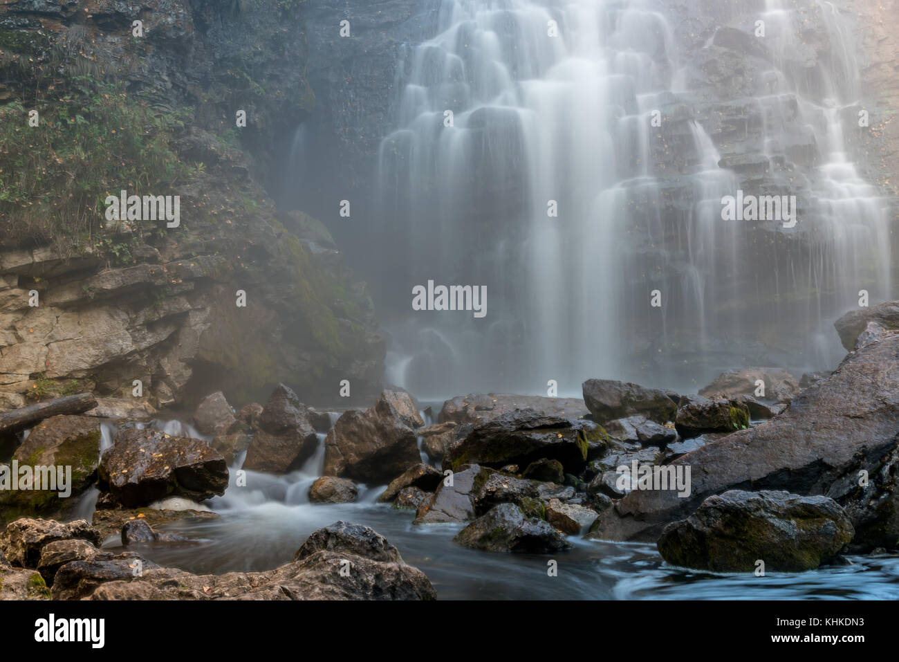 Beautiful view of the waterfall with mist among the rocks and stones ...