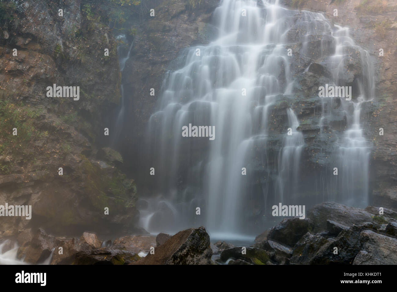 Beautiful view of the waterfall with mist among the rocks and stones ...
