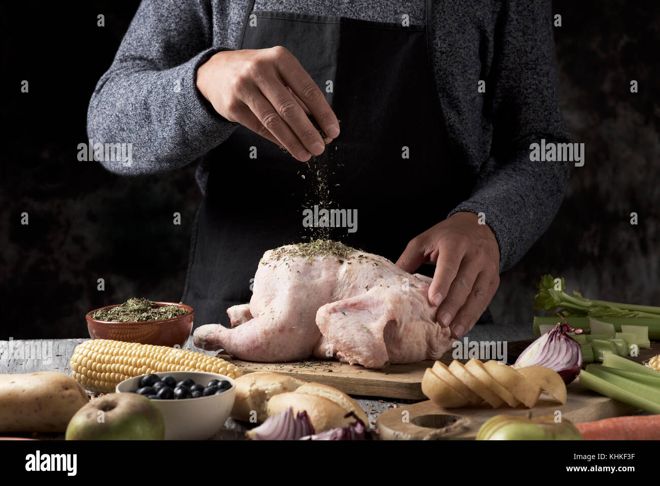 closeup of a young caucasian man preparing a turkey placed on a rustic ...