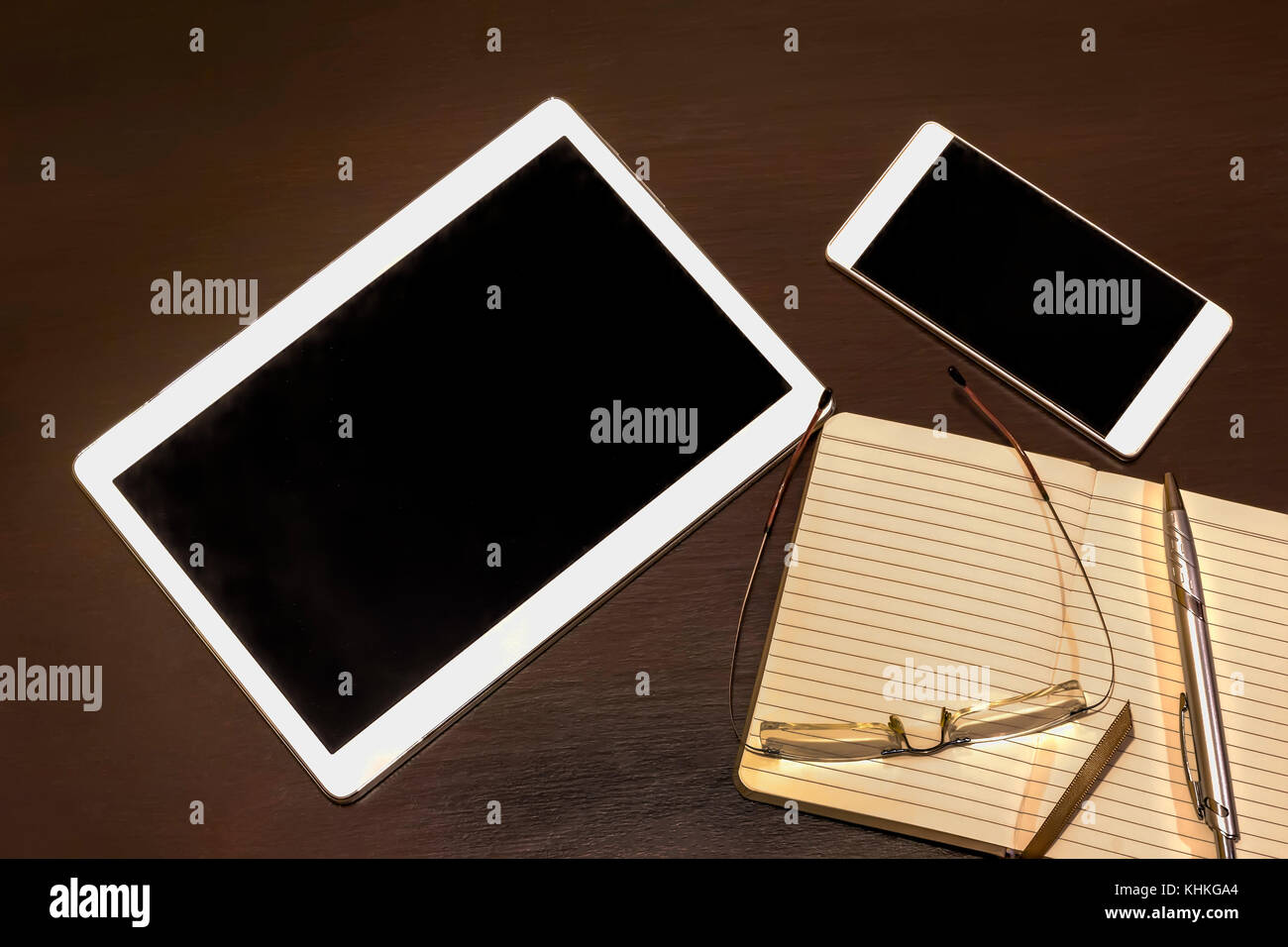Office table: mobile phone, tablet, glasses, notebook and pen with copy ...