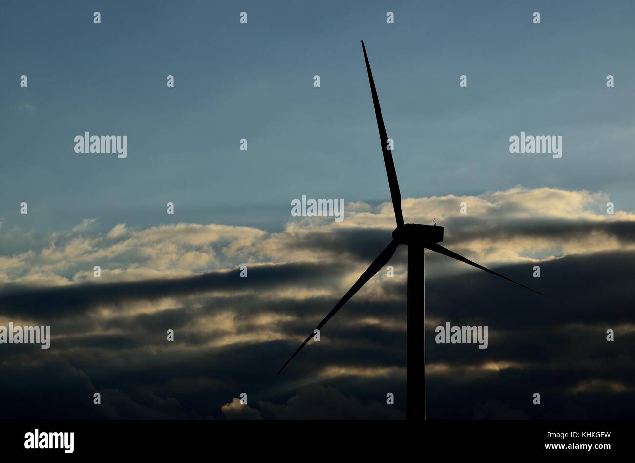 Isolated wind turbine with low clouds and blue sky at dawn Stock Photo ...