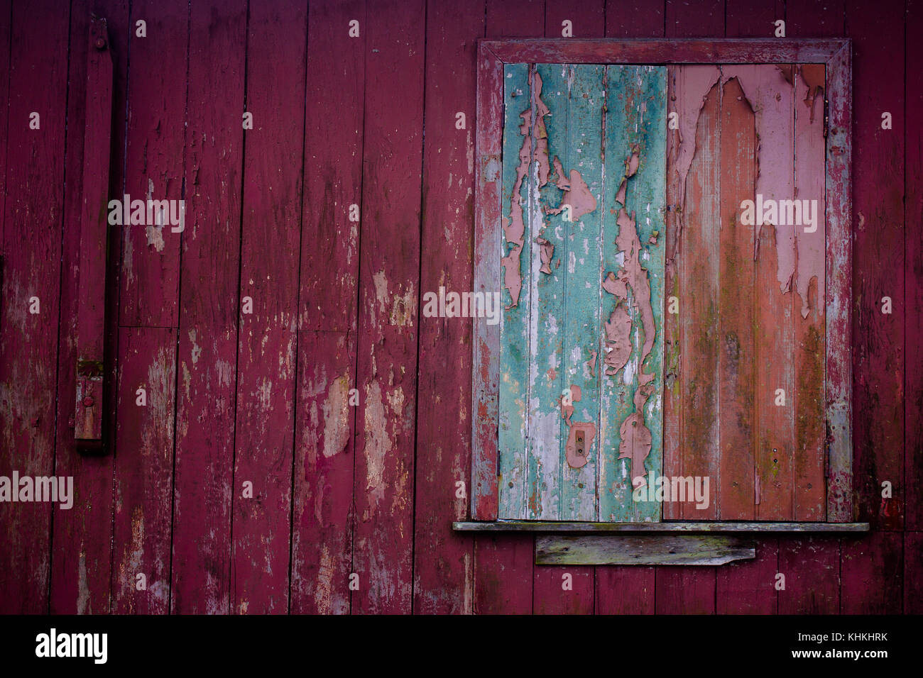 Old grunge and weathered home facade with green window and red wall ...