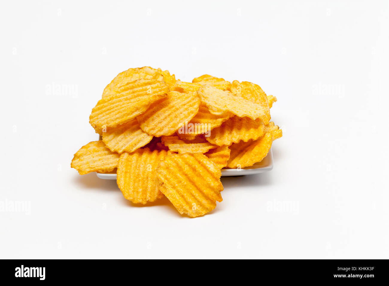 Ribbed potato chips with spices on white background Stock Photo - Alamy