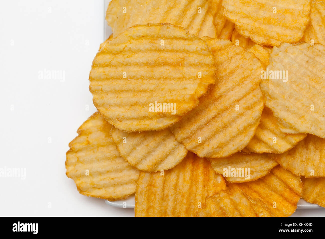 Ribbed potato chips with spices on white background Stock Photo - Alamy