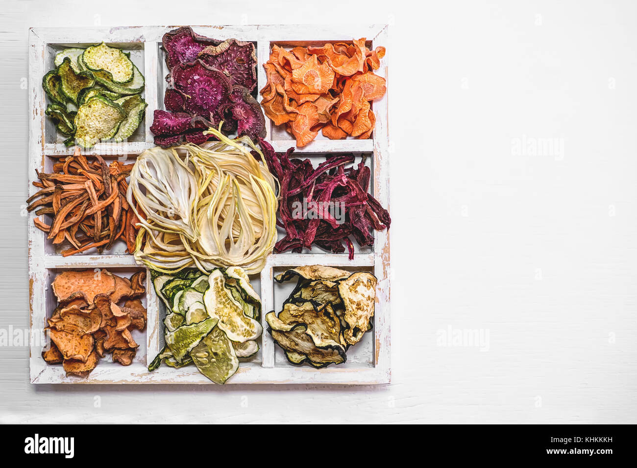 Homemade colorful chips of different fresh vegetables in a white wooden ...