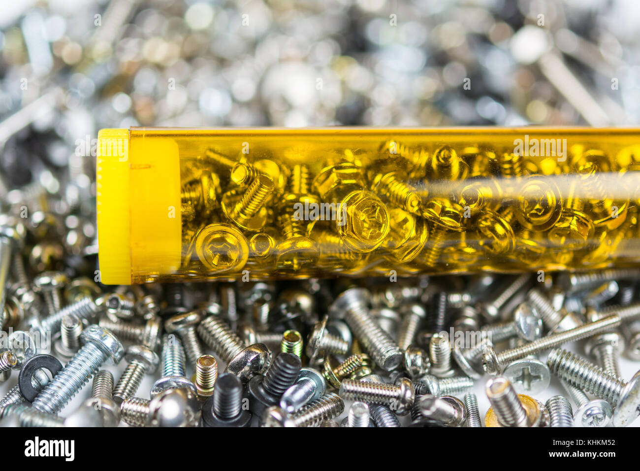Small screws in transparent box. Silver bolts in nice yellow tube with ...