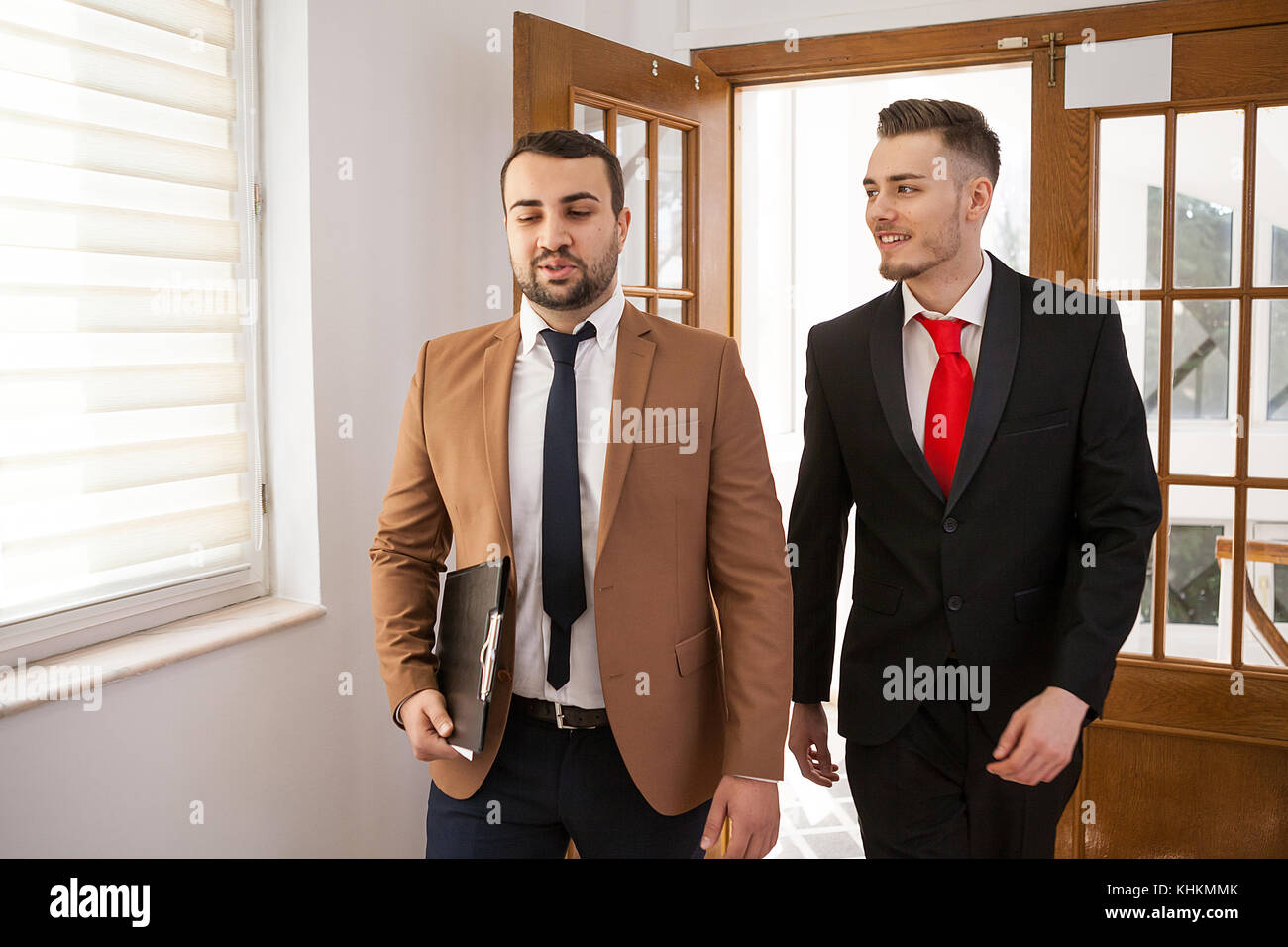 Business partners in formal suit walking and talking Stock Photo - Alamy