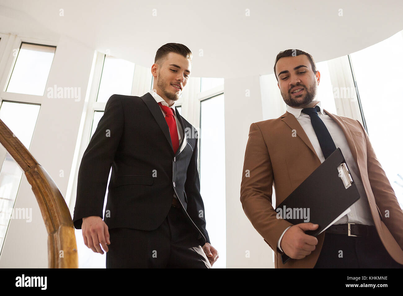 Business partners in formal suit walking and talking Stock Photo - Alamy