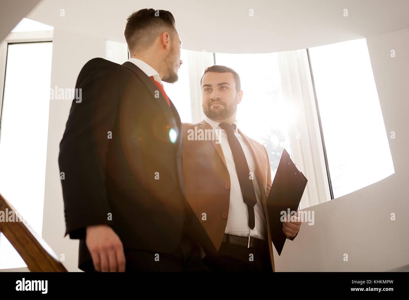 Two male business partners walking and talking Stock Photo - Alamy