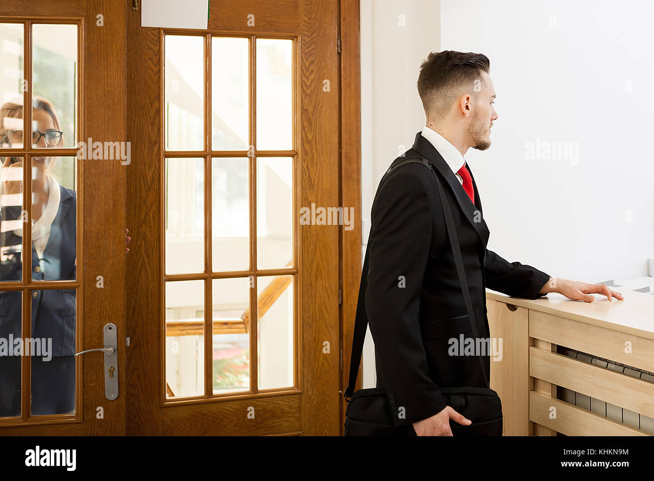Businessman in office reception area talking with secretary Stock Photo ...