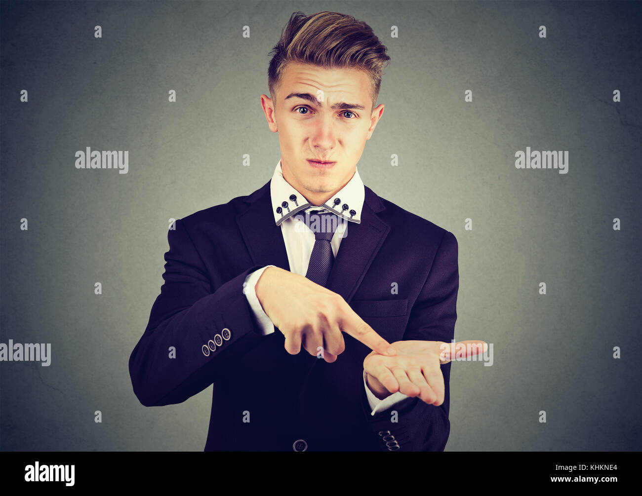 Young serious businessman asking for more money to pay back debt Stock ...