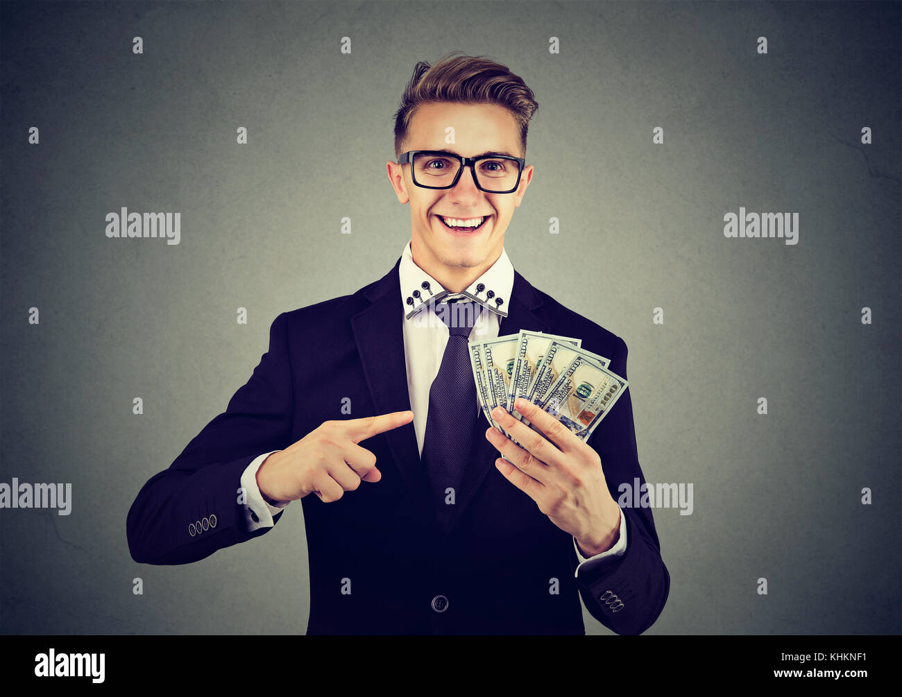 Successful young business man holding money dollar bills in hand ...