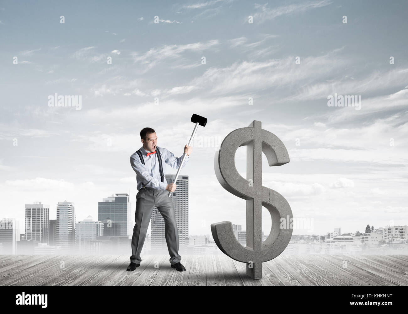 Determined banker man against modern cityscape breaking dollar concrete ...