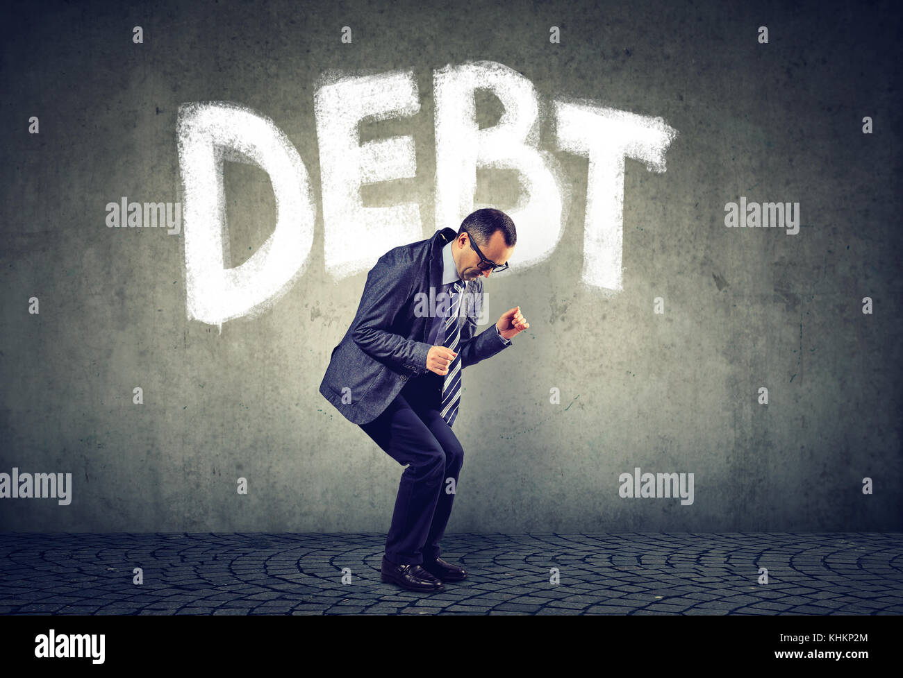 Stressed business man under debt pressure Stock Photo - Alamy