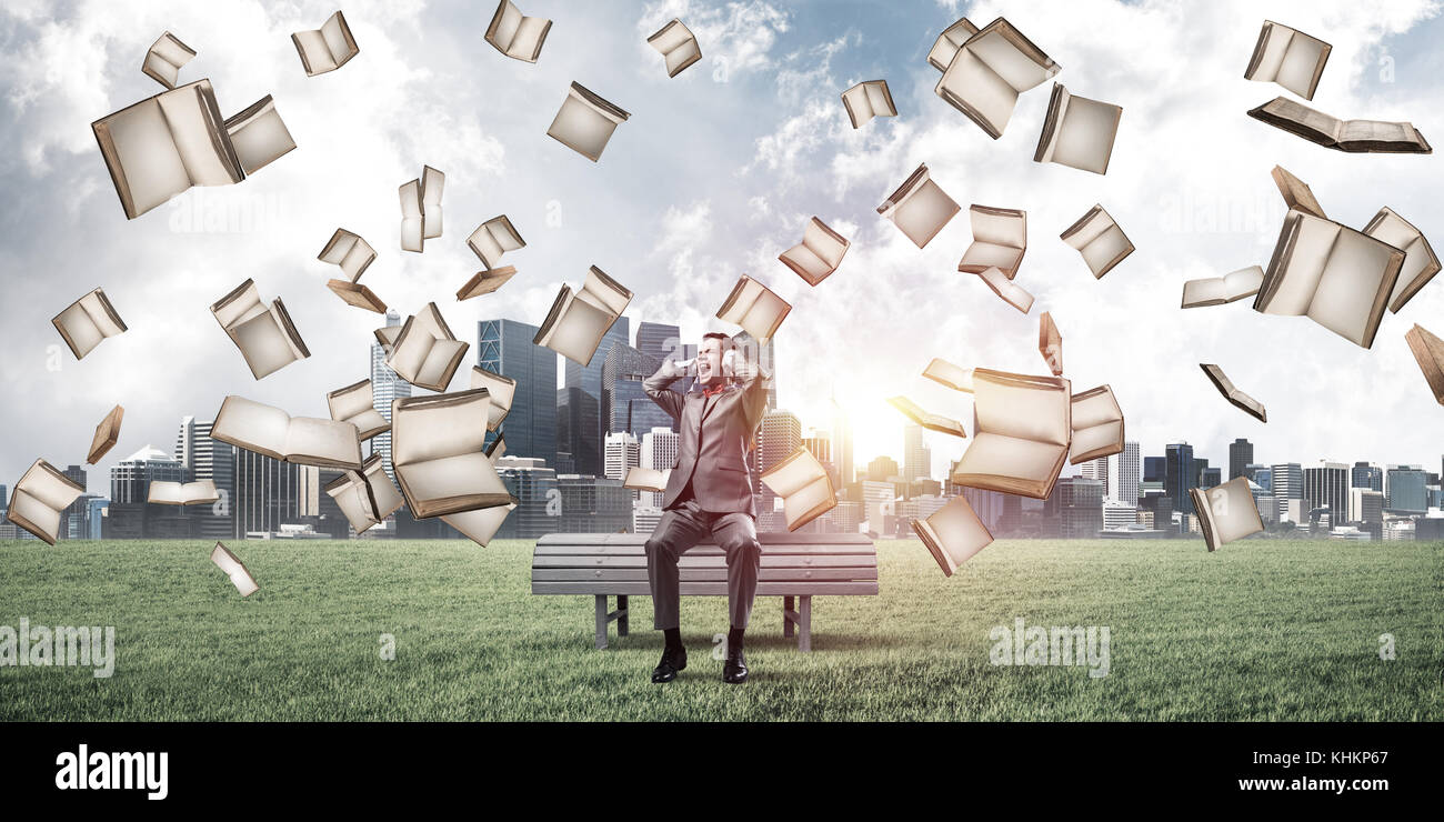 Many old books falling from above and student guy sitting on ben Stock ...