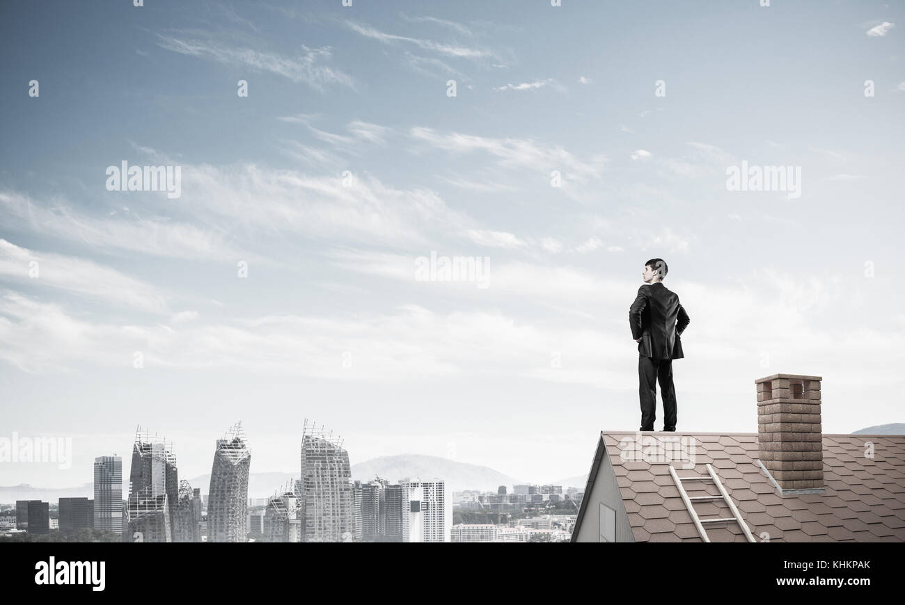 Mister boss on brick roof with arms akimbo. Mixed media Stock Photo - Alamy