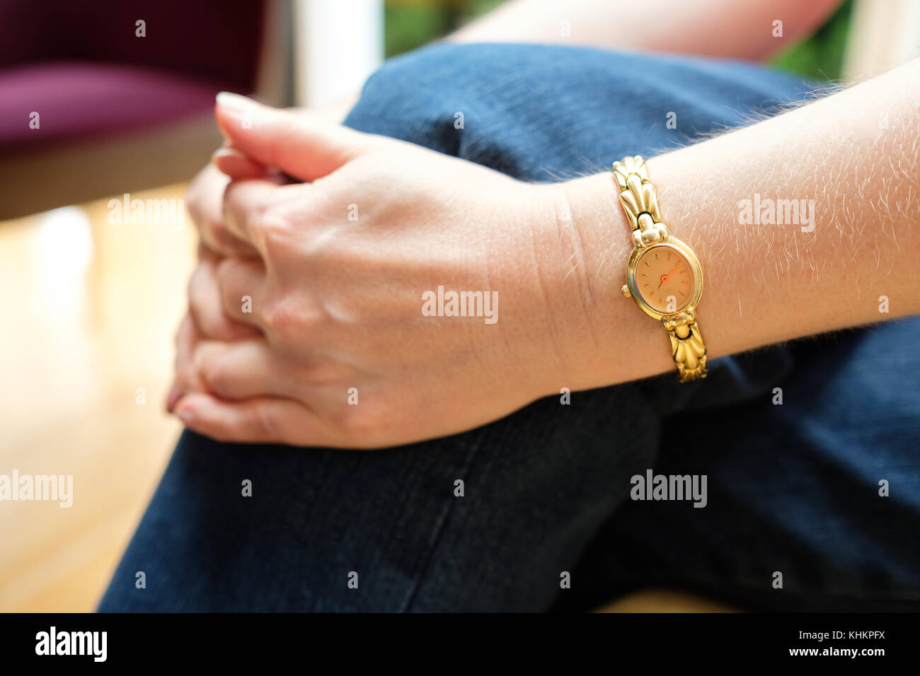 Folded hands and arm with golden watch holding a foot Stock Photo - Alamy