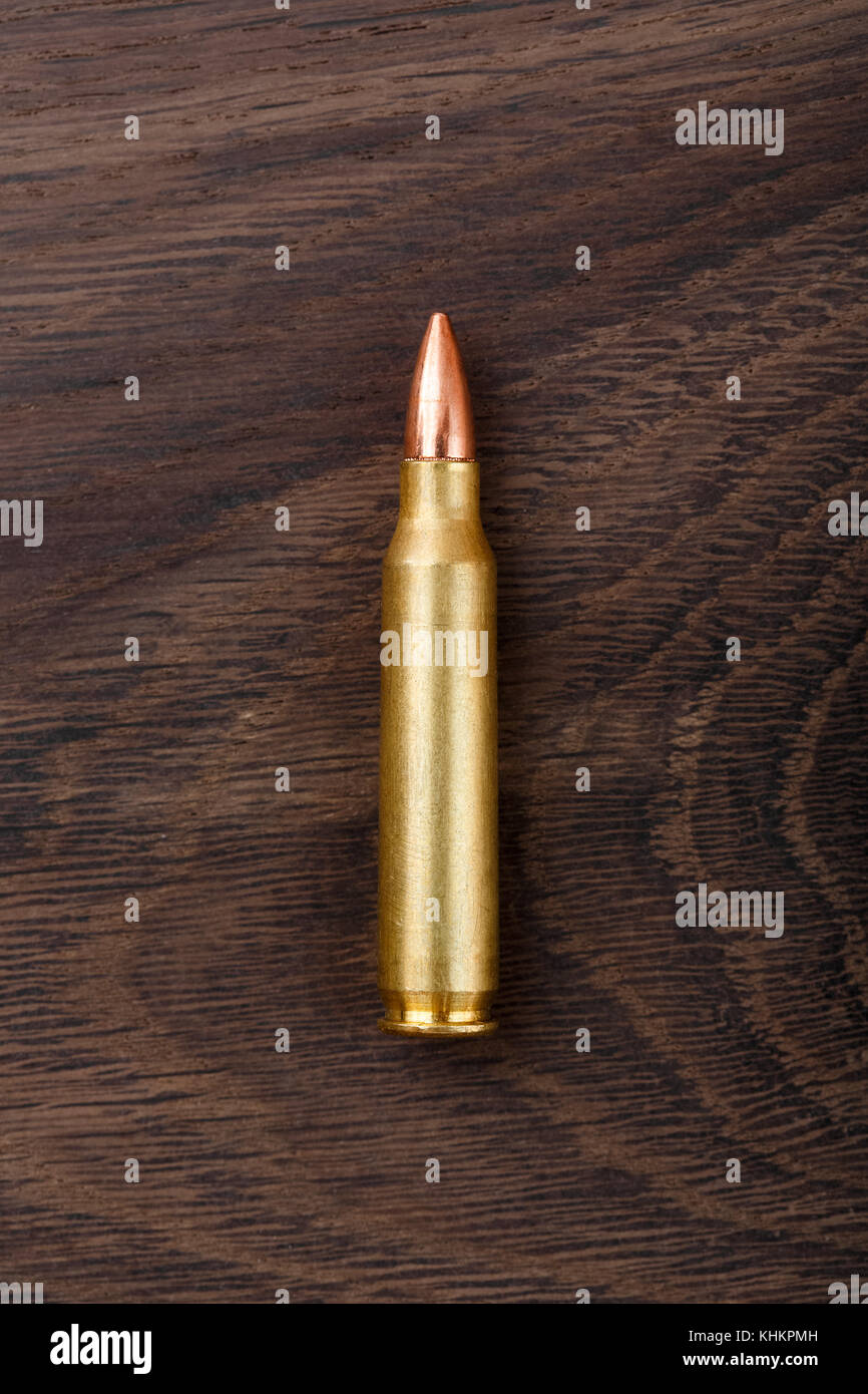 Single rifle bullet on wooden background. High resolution photo Stock ...
