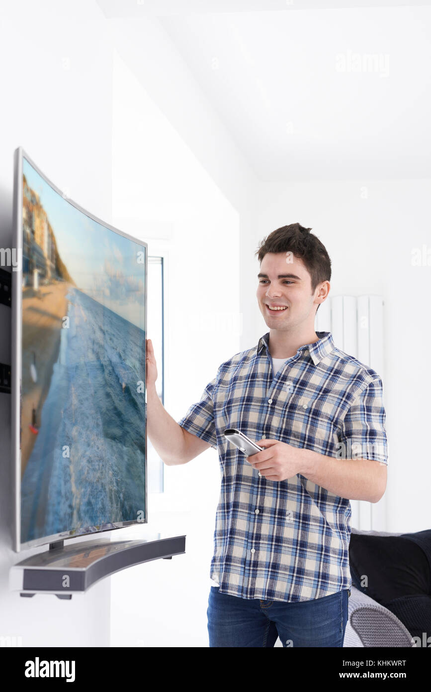 Young Man With New Curved Screen Television At Home Stock Photo - Alamy